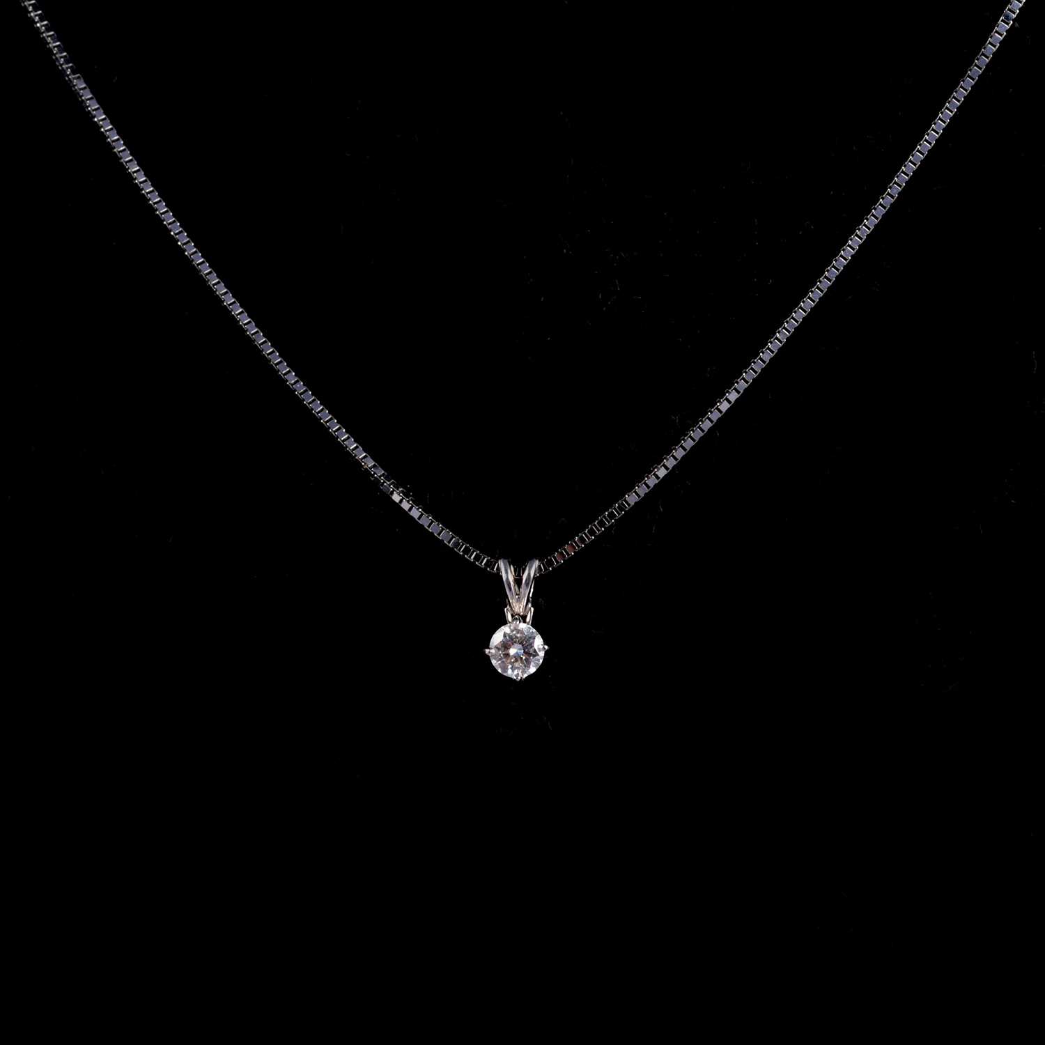 Lot 255 - A diamond solitaire pendant on a chain.