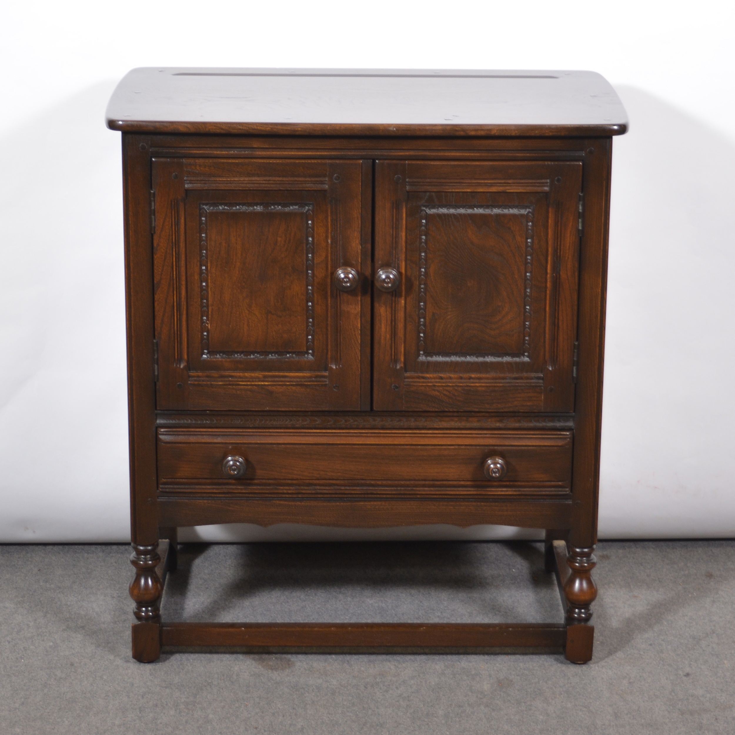 Lot 519 - Ercol dark elm cabinet,