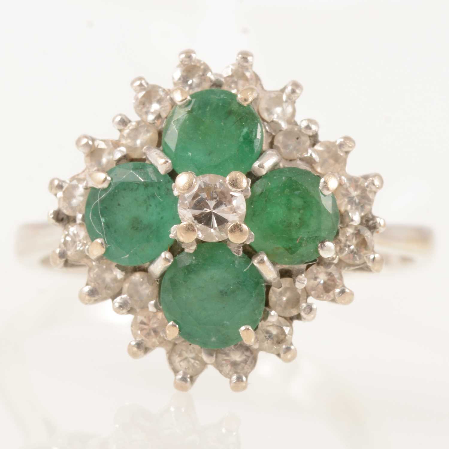 Lot 301 - An emerald and diamond cluster ring.