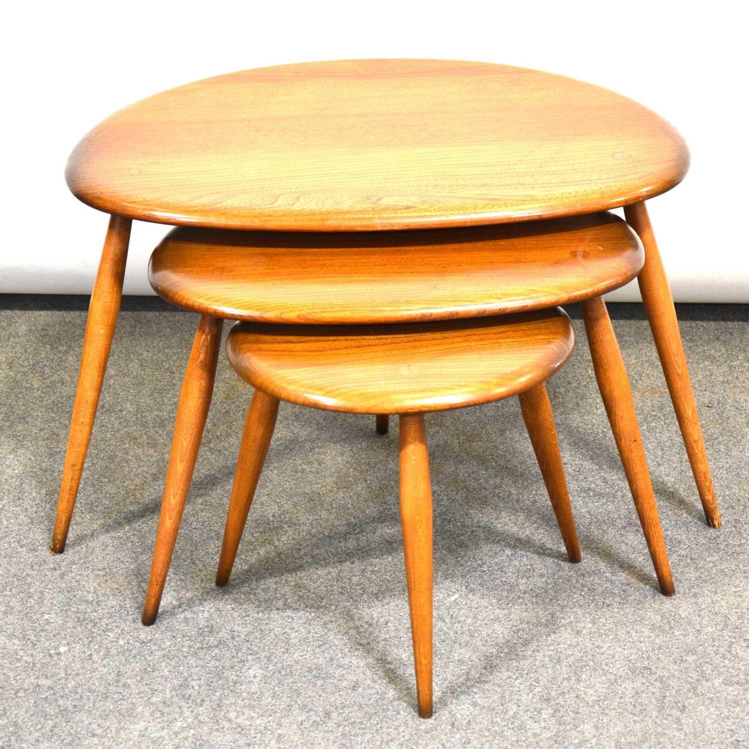 Lot 424 - Ercol, a nest of three 'Pebble' occasional